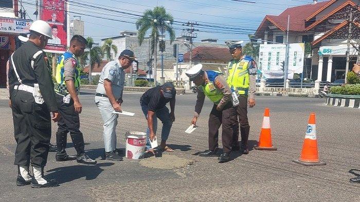 Anggota Satlantas Polres Bireuen Bersama Warga Tutup Lubang Jalan - Serambinews.com