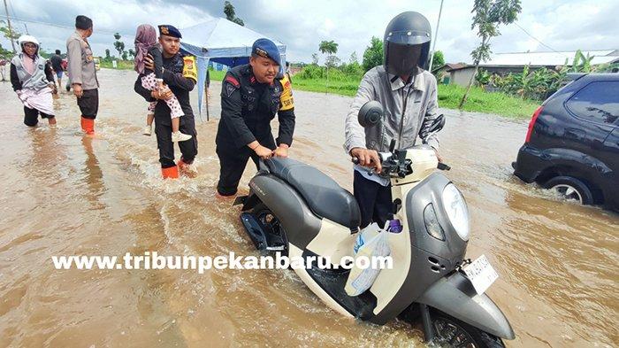 FOTO : Anggota Brimob Polda Riau Bantu Dorong Kendaraan yang Mogok Saat Lewati Banjir ...